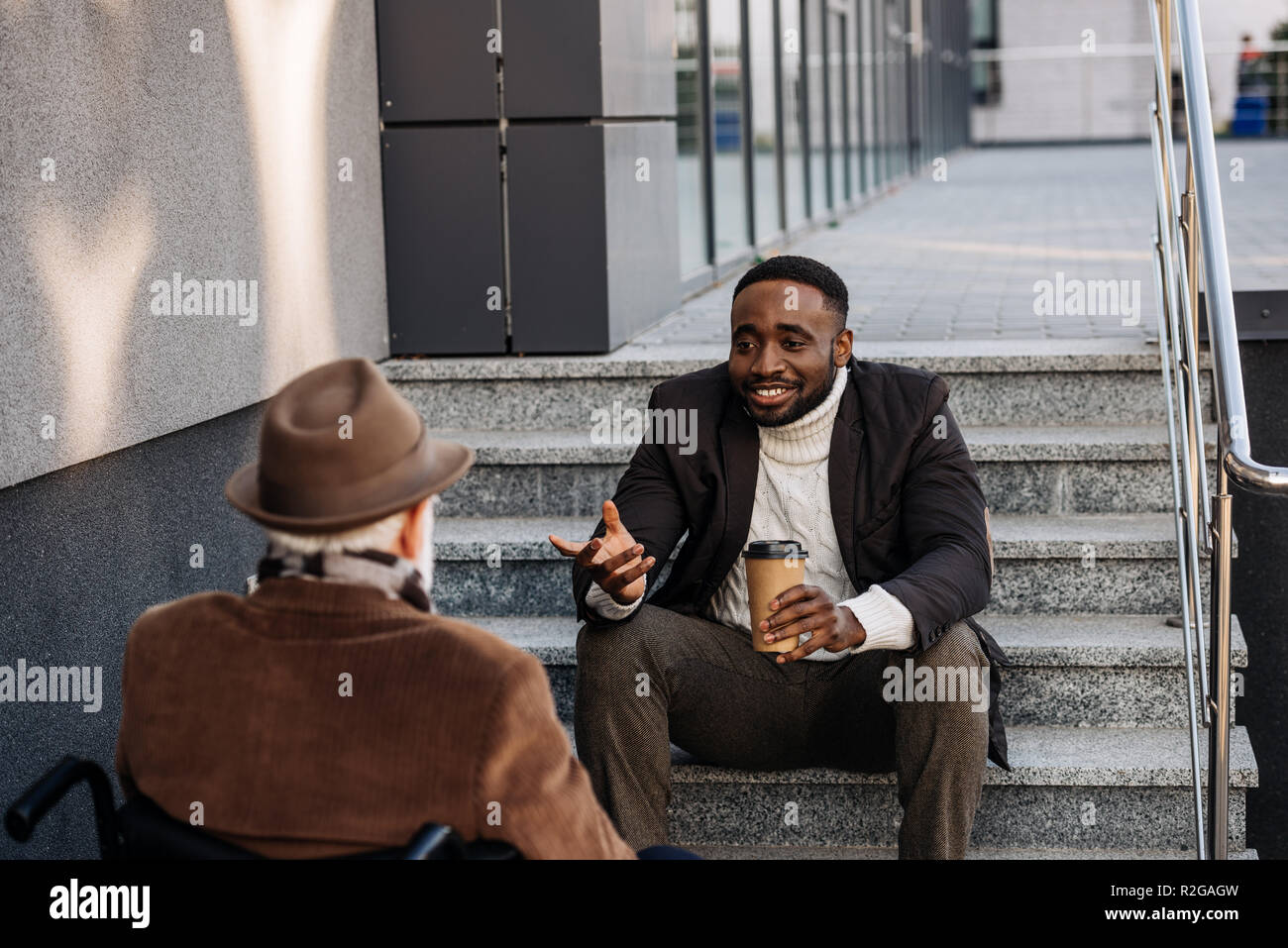 Senior Disabled Man In Wheelchair And African American Man Drinking