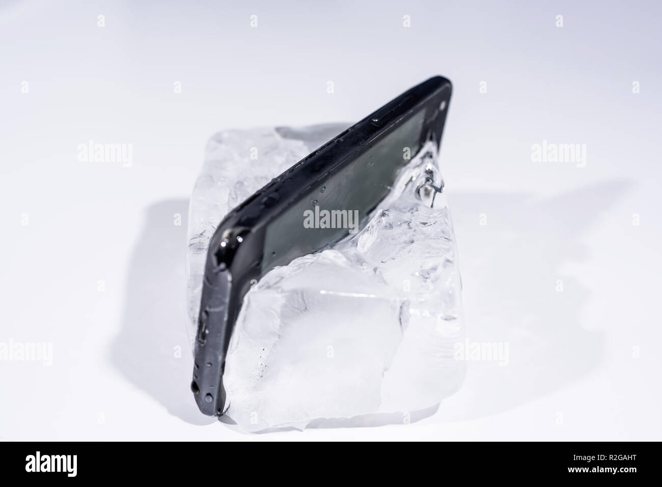Black smartphone frozen in ice. Abstract object photo Stock Photo - Alamy