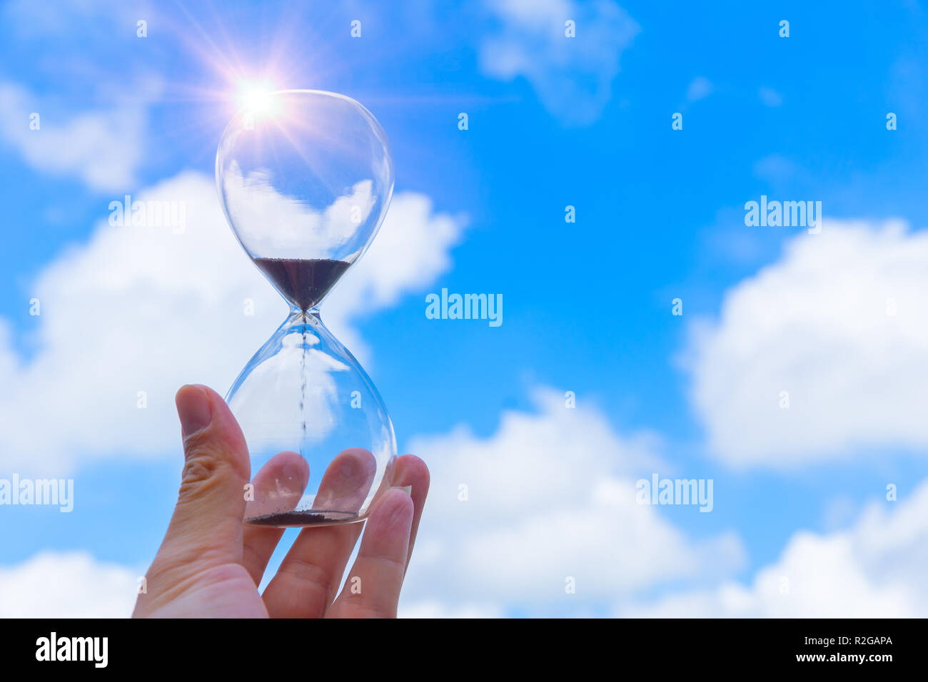 Hourglass Sand Timer Clock time hand holding with blue sky cloud ...