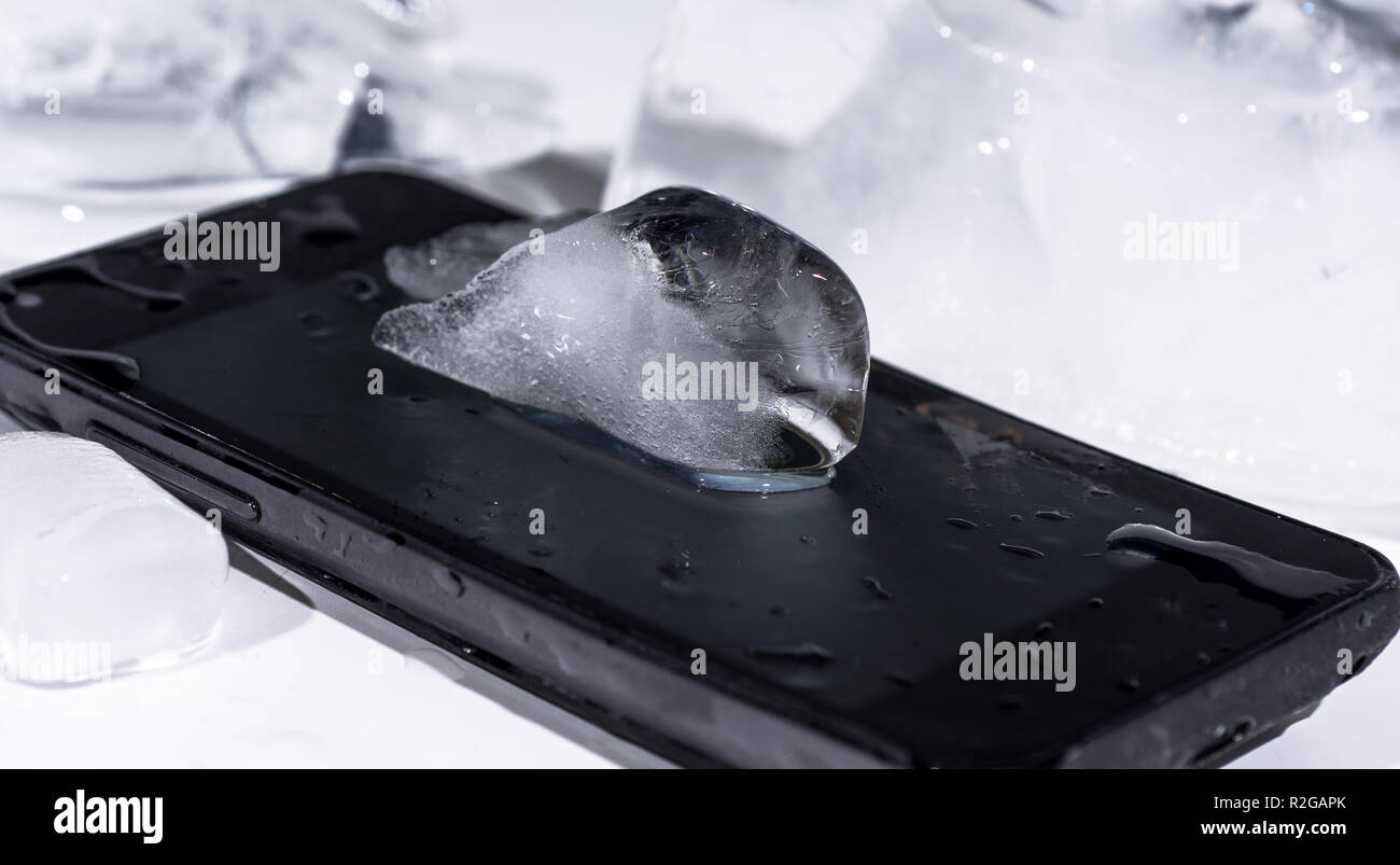 Black smartphone frozen in ice. Abstract object photo Stock Photo - Alamy