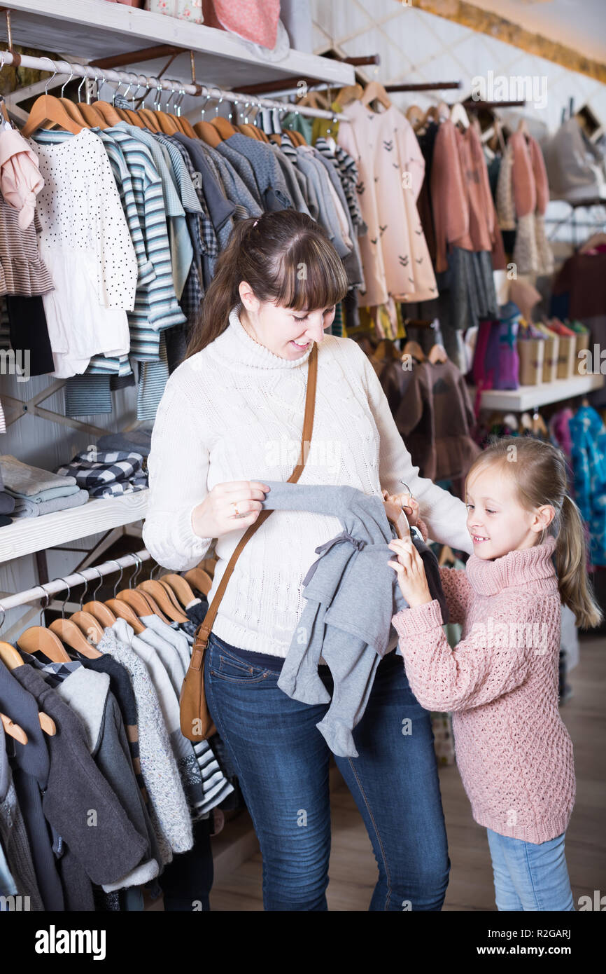 Smiling girl with her mother selected the sliders to the baby in ...