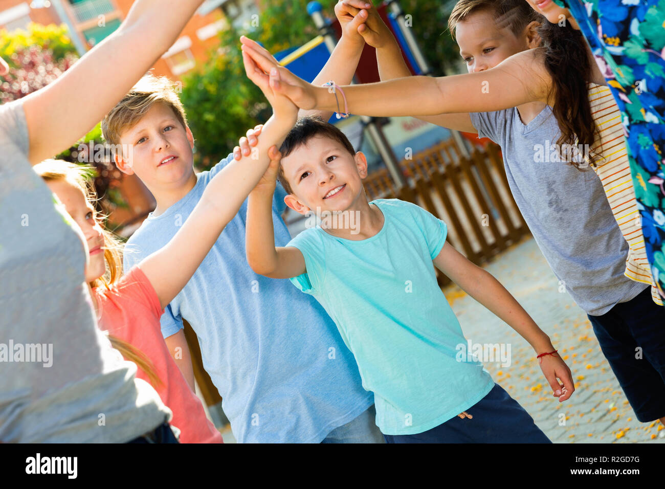 Group of glad positive smiling children playing at the playground ...