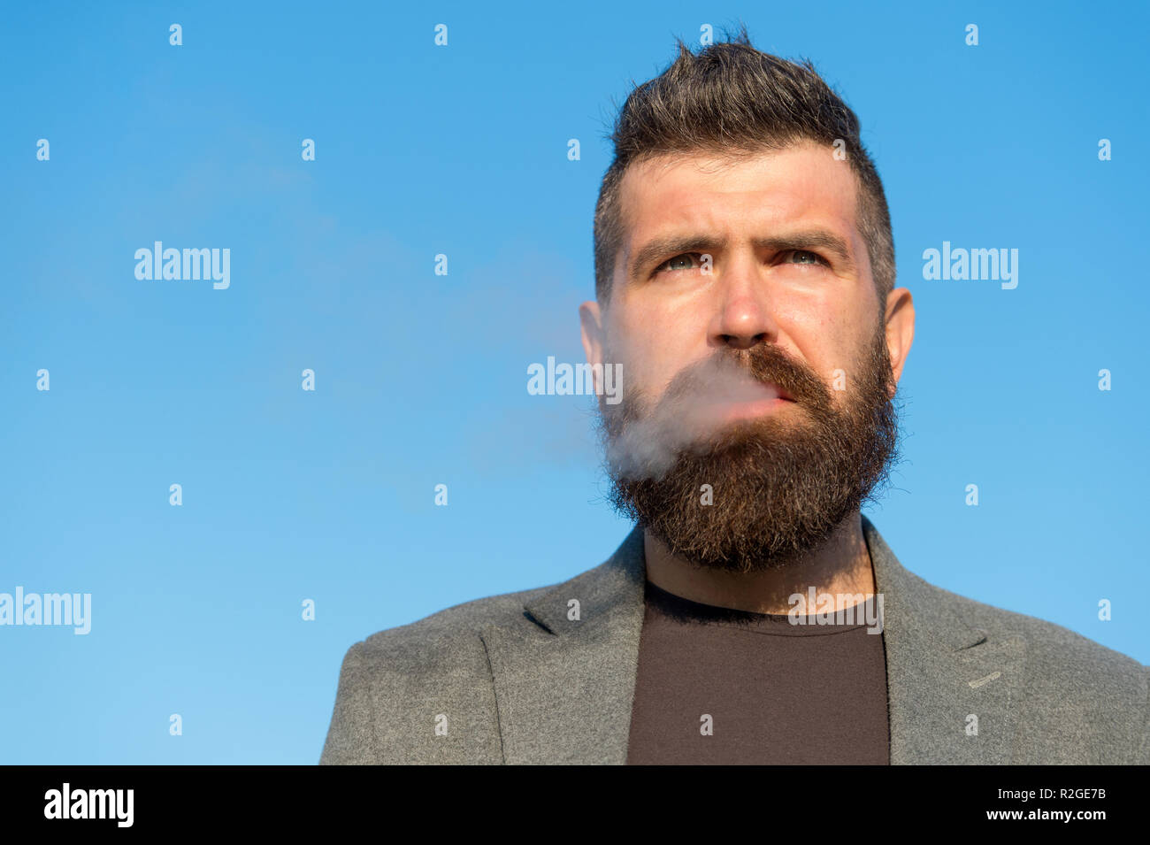 Man with beard and mustache smoking blue sky background. Smoking and ...