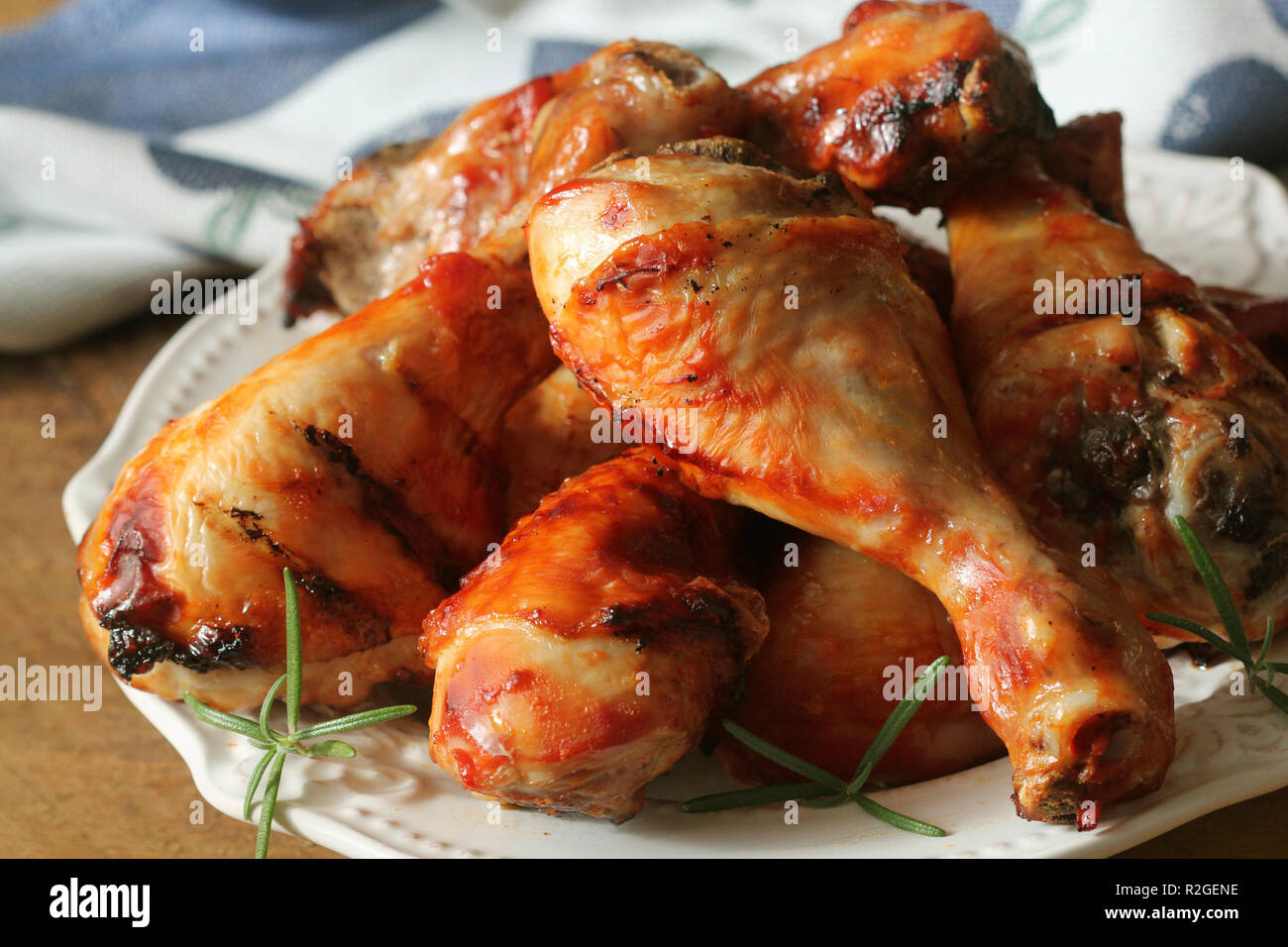 Grilled chicken legs with rosemary served on white plate. Dinner ...
