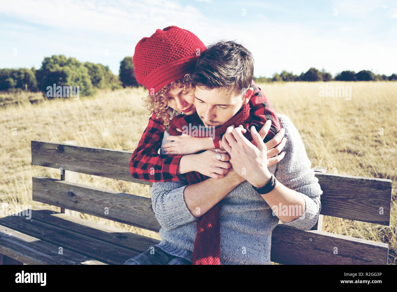 A couple of happy young millennials in love sunbathing and sitting on a ...