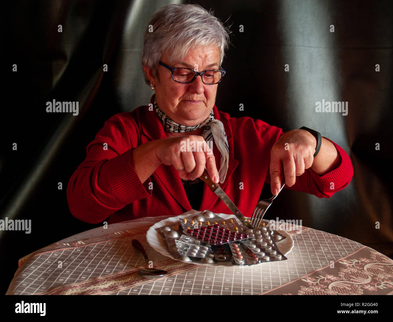 Concept of medicine and health care. A senior woman cutting several ...