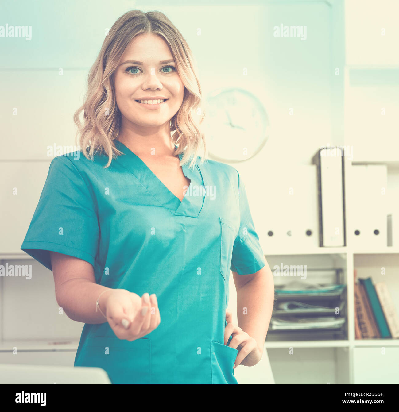 Kindly woman in doctor's uniform greets visitors at modern office Stock ...