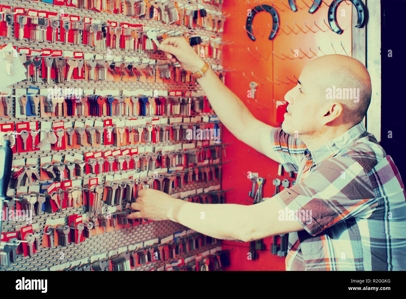 Mature professional hanging new key on stand in locksmith Stock Photo ...