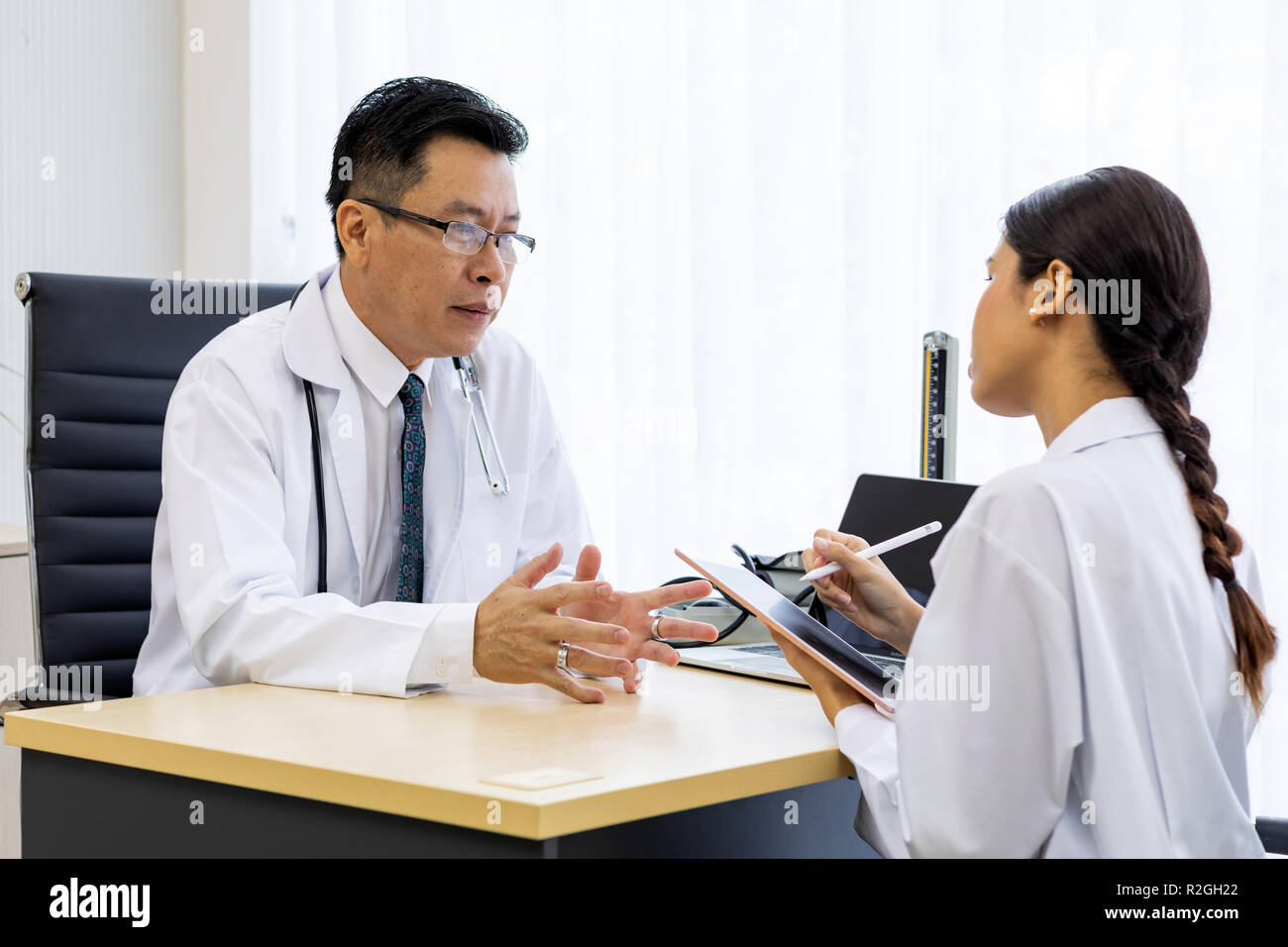 Two doctors in the hospital discuss the diagnos of the patient Stock ...