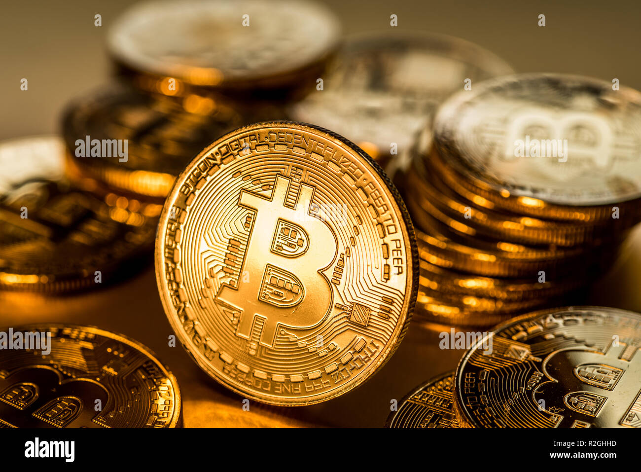 Shiny physical bitcoins on golden background. Blockchain technology ...