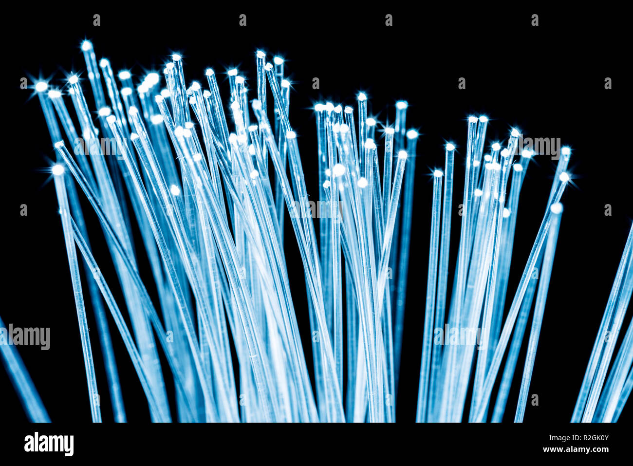 Bundle of optical fibers with blue light. Black background Stock Photo ...