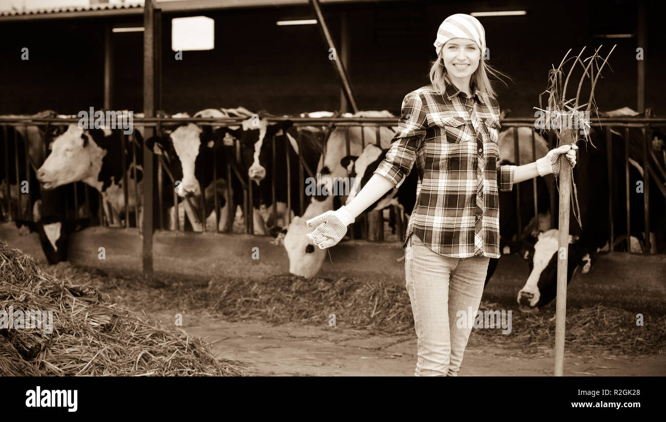 Female cattle-farm worker preparing grass for feeding cows Stock Photo ...
