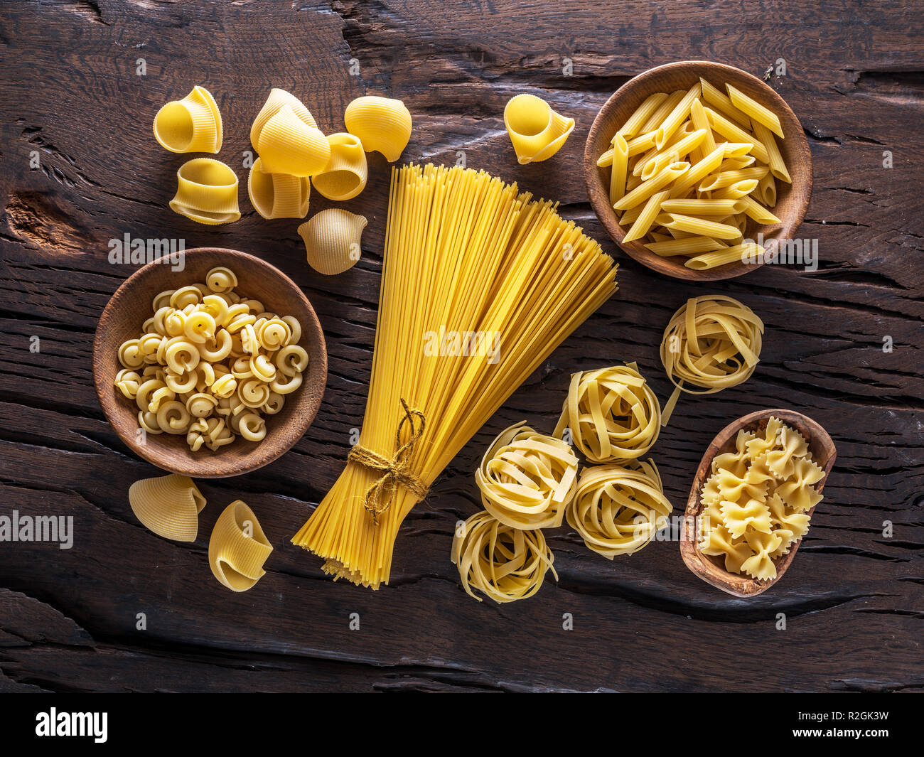 Different pasta types on the wooden table Stock Photo - Alamy
