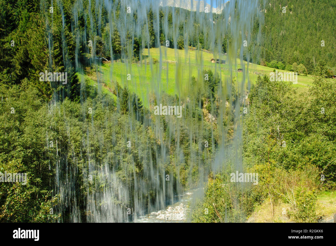 Tyrolean Alpine landscape as seen through a curtain of water from ...
