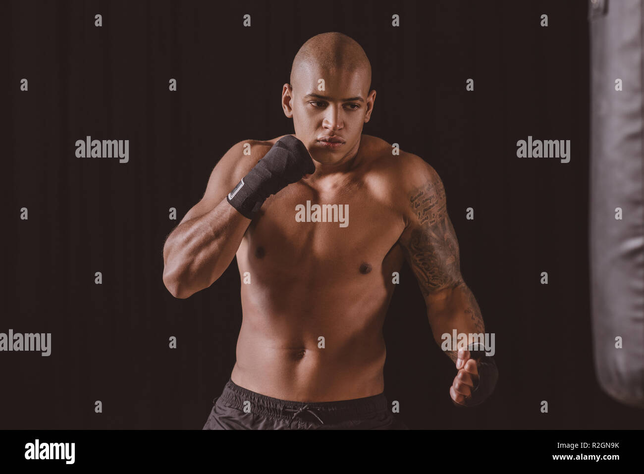 male boxer in boxing bandage training with punching bag at gym Stock ...