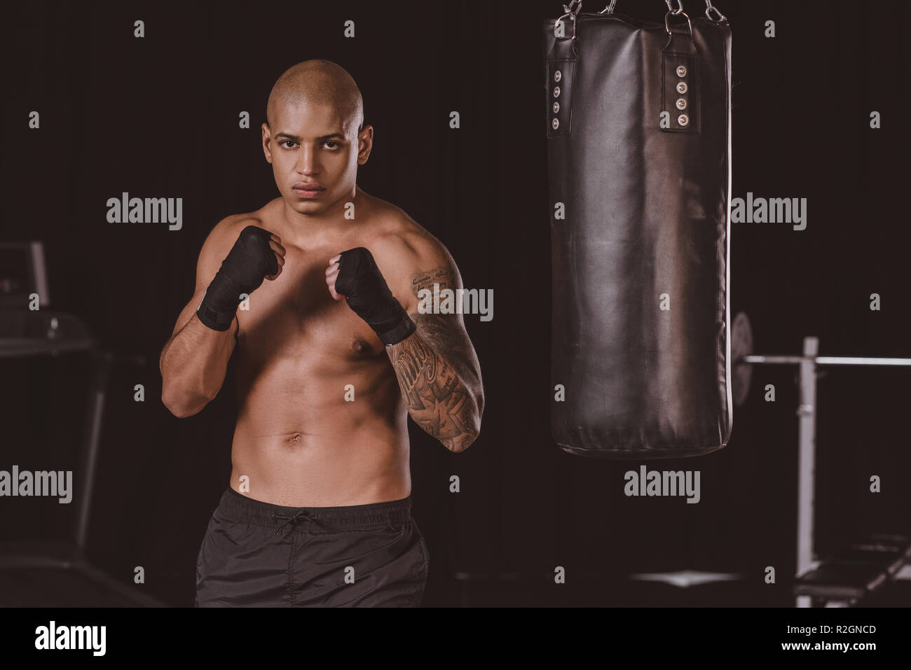 serious african american boxer posing in fight position near punching ...