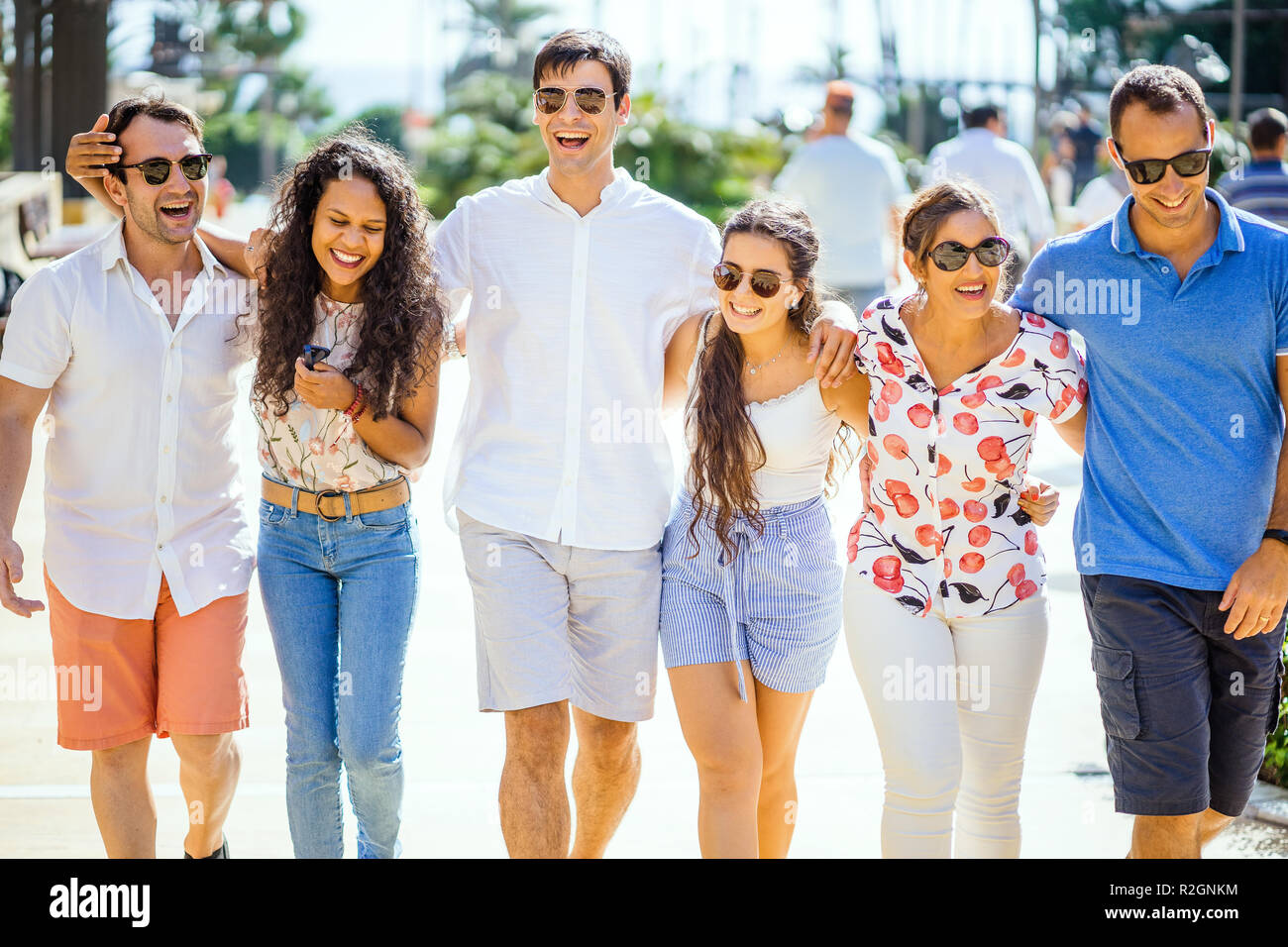 Six friends walking, taking, laughing and having fun during day time in ...
