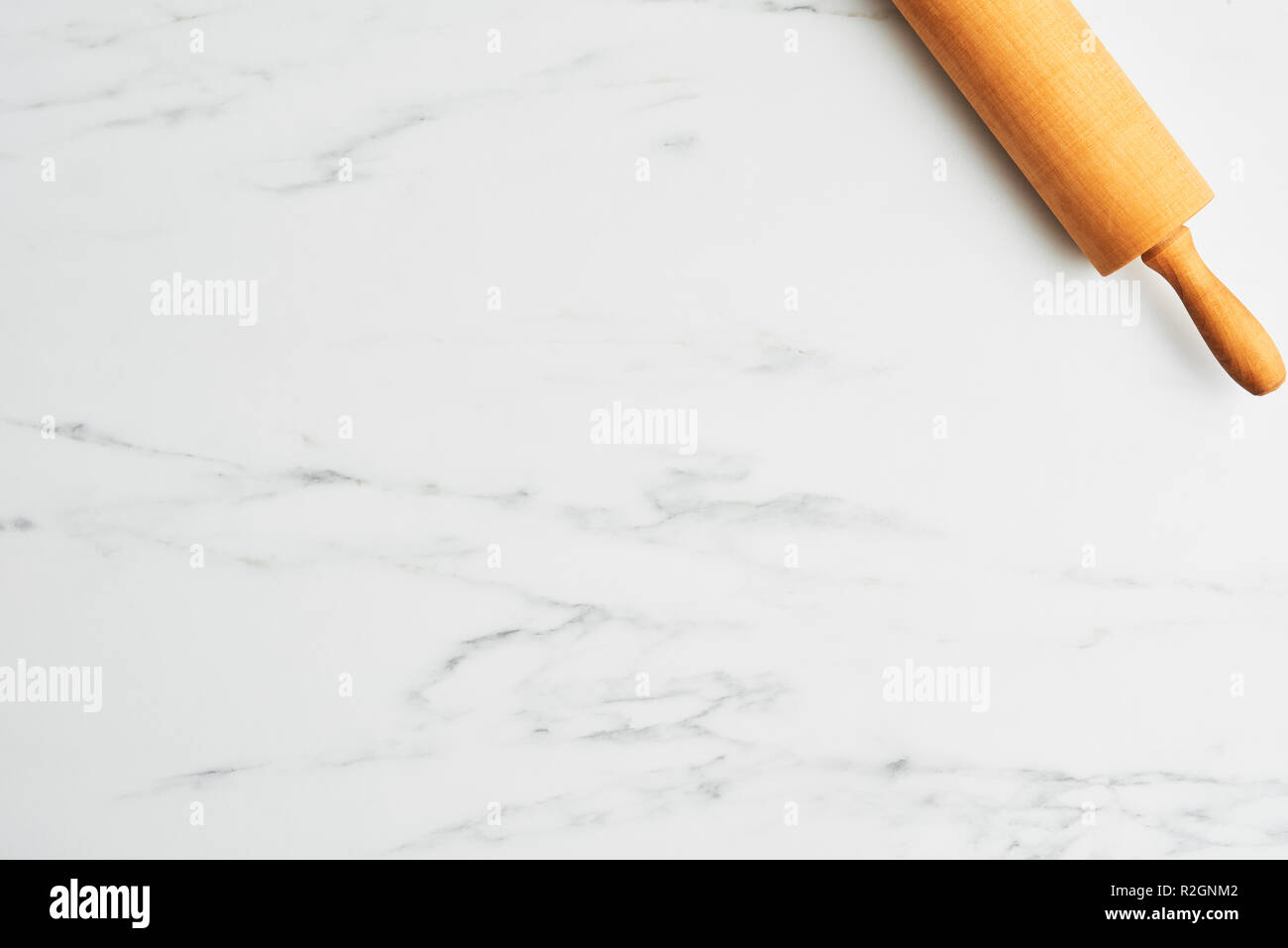 Simple baking background with rolling pin on white marble table. Top ...