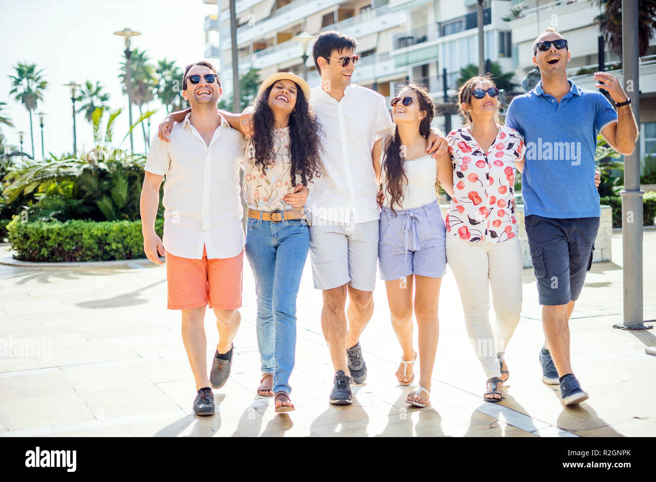 Six friends walking, taking, laughing and having fun during day time in ...