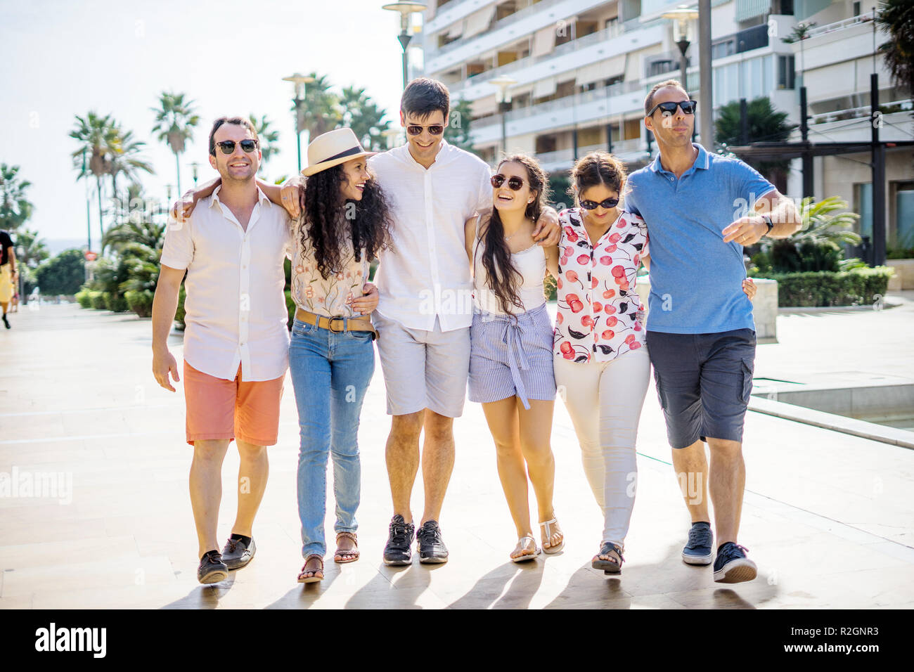 Six friends walking, taking, laughing and having fun during day time in ...