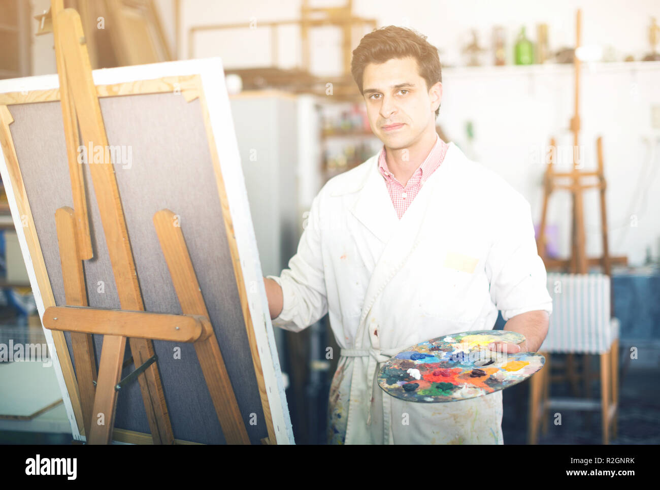Creative male artist drawing picture with oil paints in studio Stock ...