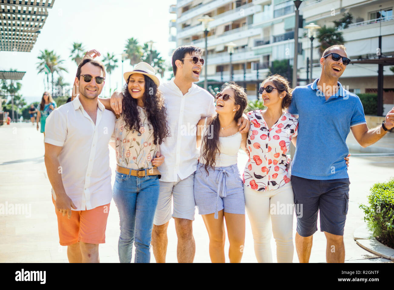 Six friends walking, taking, laughing and having fun during day time in ...
