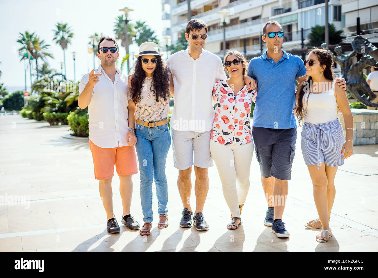 Six friends walking, taking, laughing and having fun during day time in ...