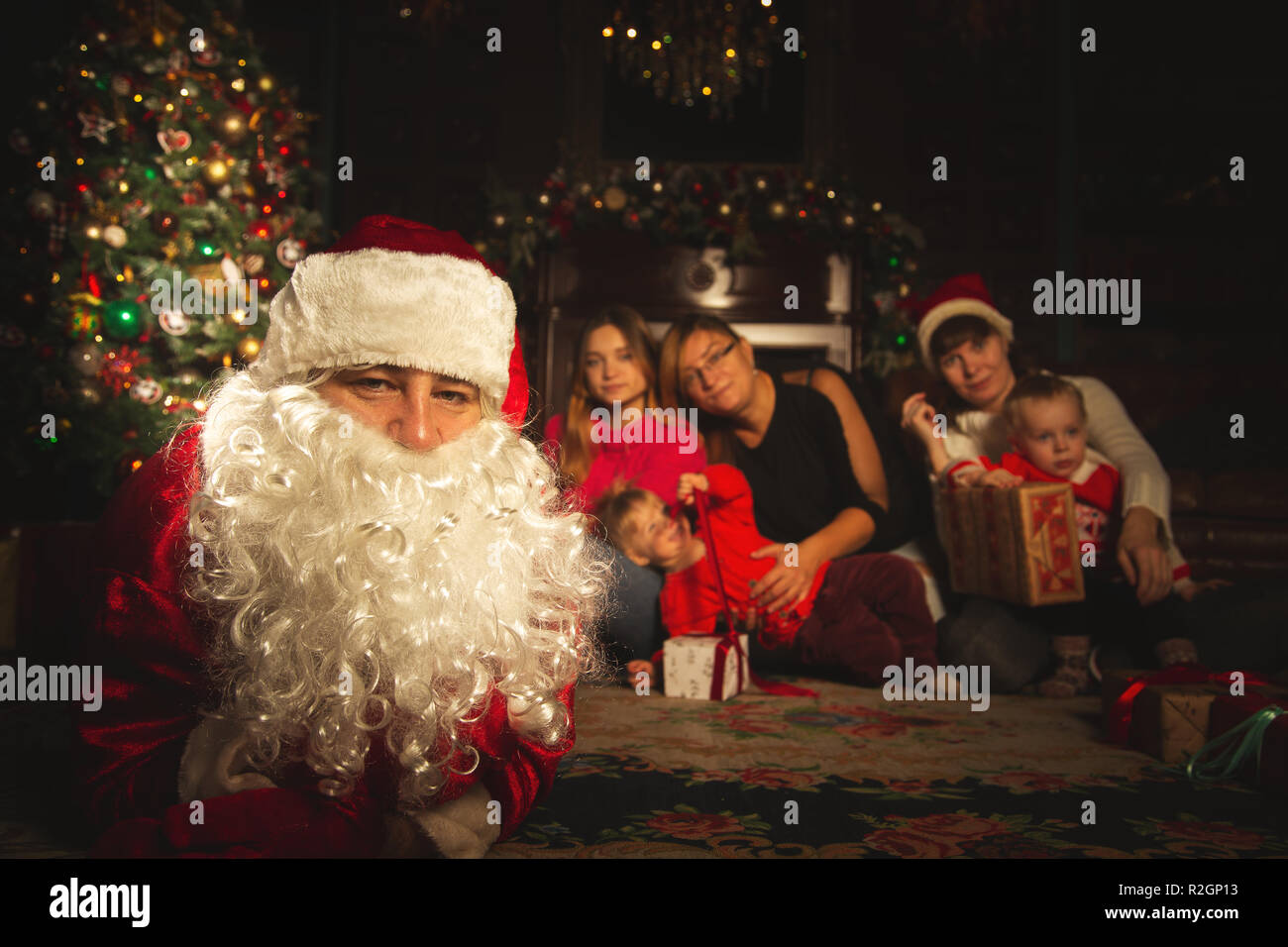 Christmas family portrait in a festive living room with a real Santa ...