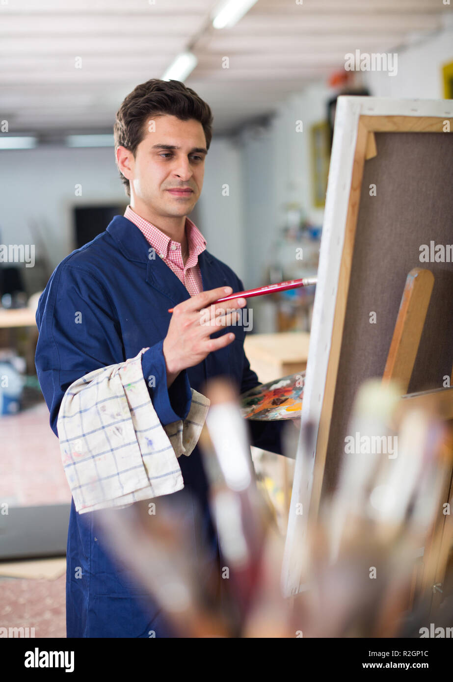 Happy art painter holding artist palette and painting on canvas Stock ...