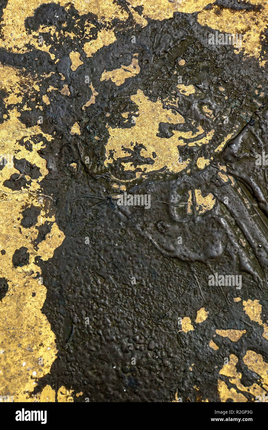 black tar smudges on a yellow wall. With a bit of imagination a head ...