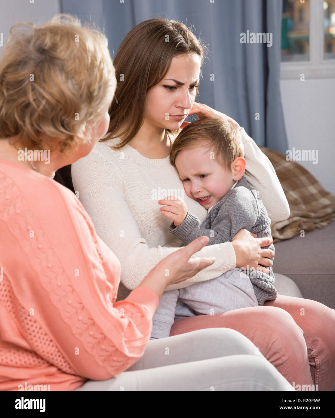 Two women are quarreling for upbringing toddler at home Stock Photo - Alamy
