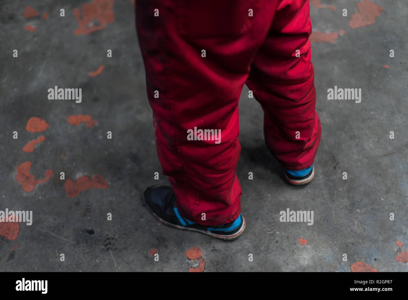 Red workwear pants on grunge gray concrete background Stock Photo - Alamy
