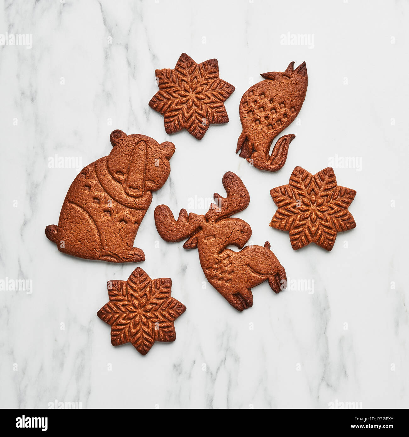 Top view of snowflake, bear, elk and fox shape gingerbread cookies on ...
