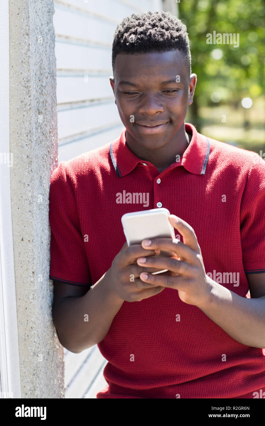 Teenage Boy Outdoors Sending Text Message From Mobile Phone Stock Photo ...