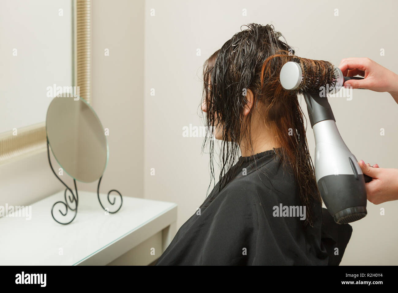 Professional hair styling concept. Hairdresser drying woman dark long ...
