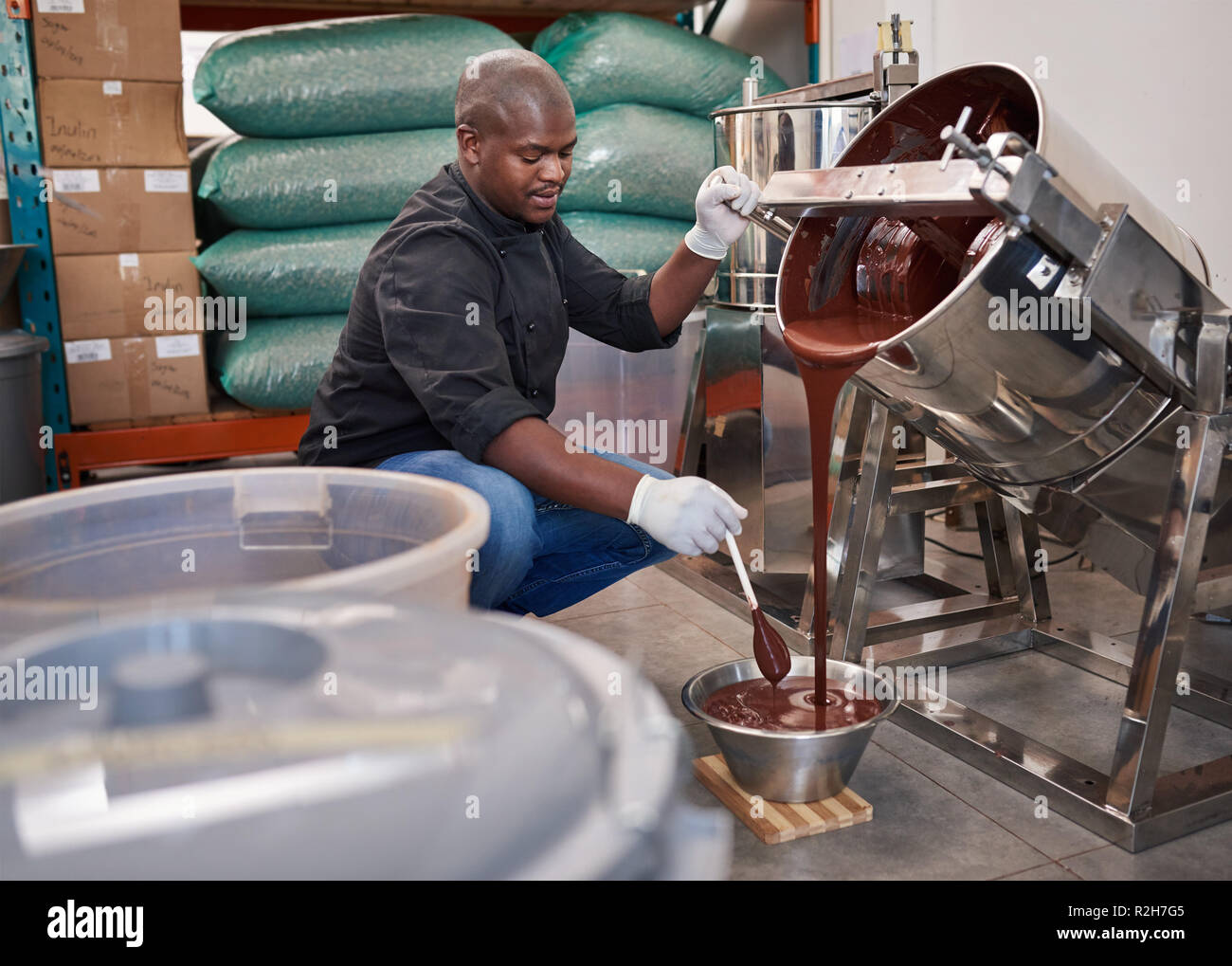 Worker melting chocolate while working in a confectionary factory Stock ...