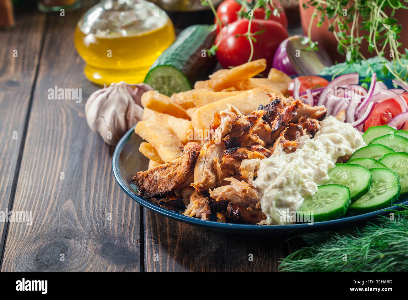 Greek gyros dish with french fries and vegetables. Served with tzatziki ...