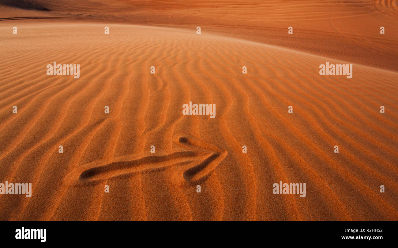 arrow in the desert sand pointing right Stock Photo - Alamy