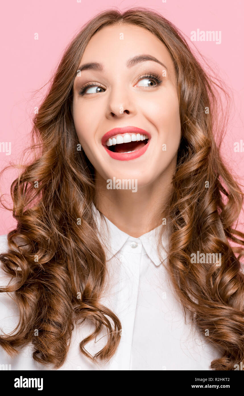 The young woman's portrait with happy emotions on pink background Stock ...