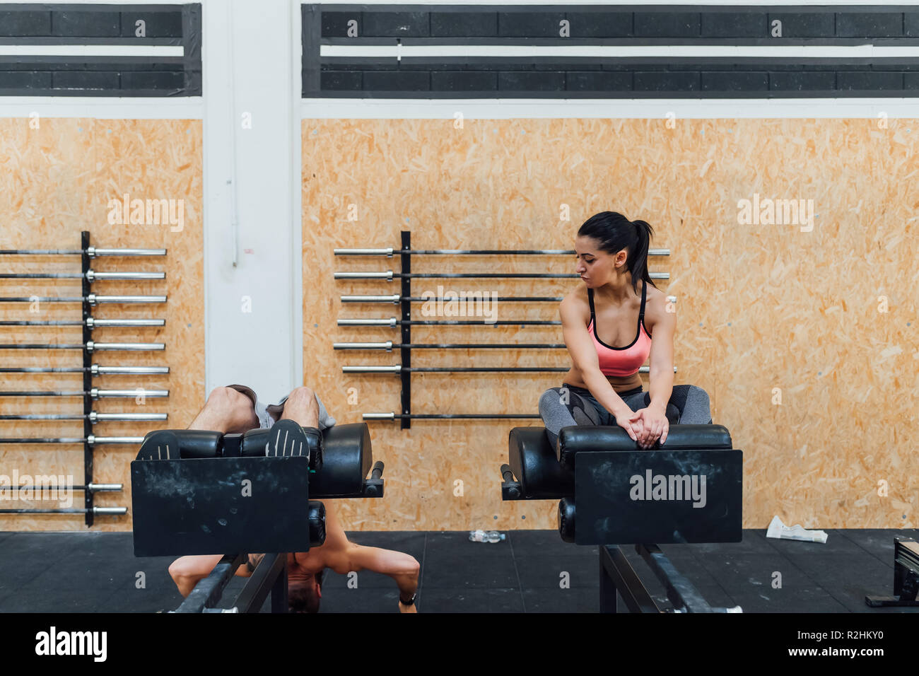 young man and woman training toghether indoor gym - crossfit, sportive ...