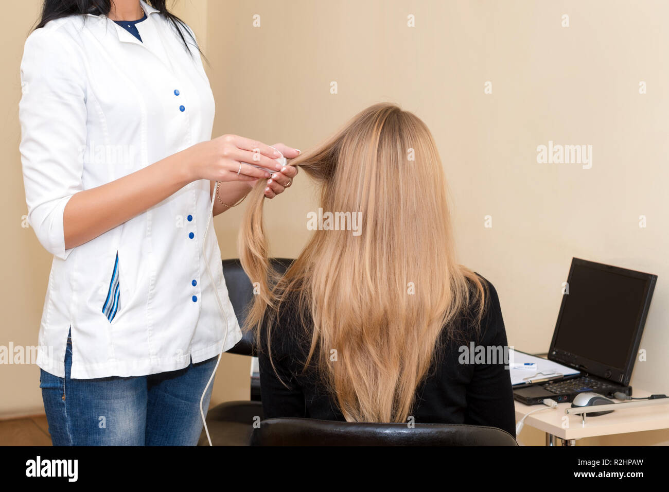 Hair doctor checking hair. Doctor examine patient female hair a special ...