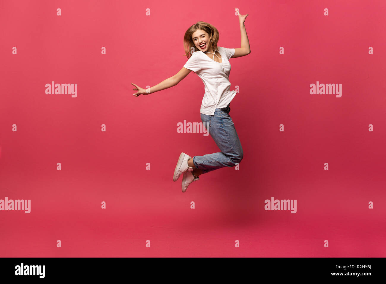 Portrait of sportive active girl in motion jumping over in the air ...