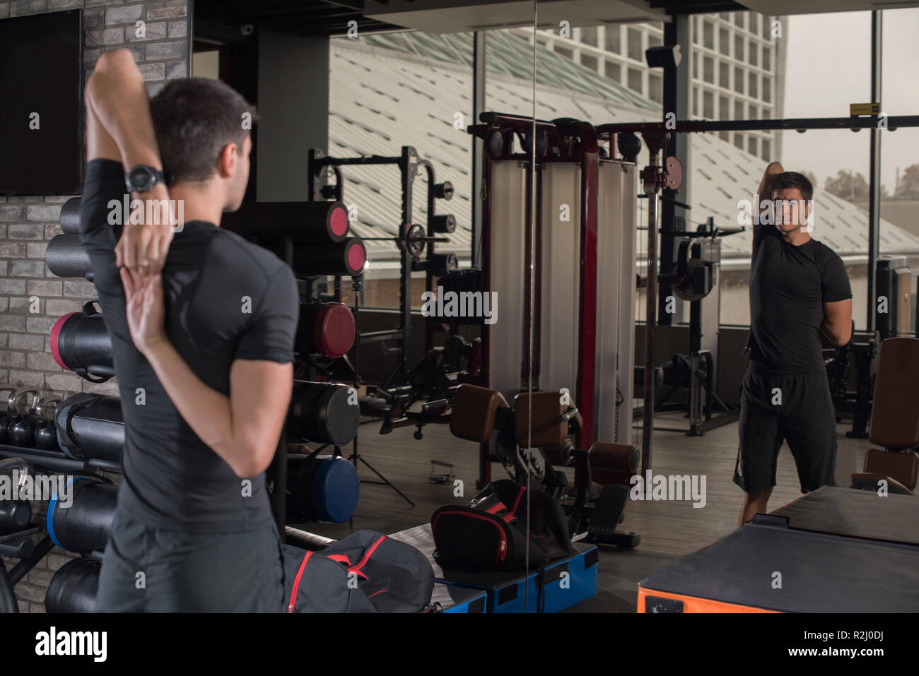 Man standing in a gym stretching his hands behind his back Stock Photo ...