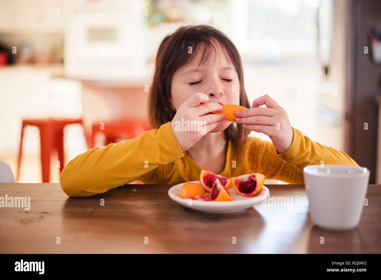 Child eating orange fruit hi-res stock photography and images - Alamy