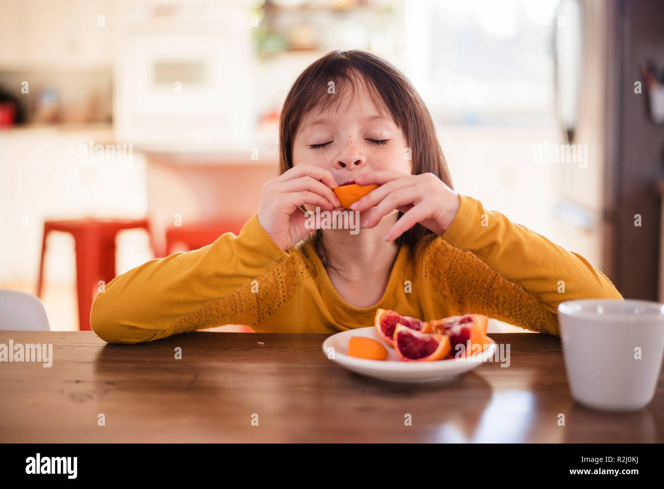 Child eating orange fruit hi-res stock photography and images - Alamy