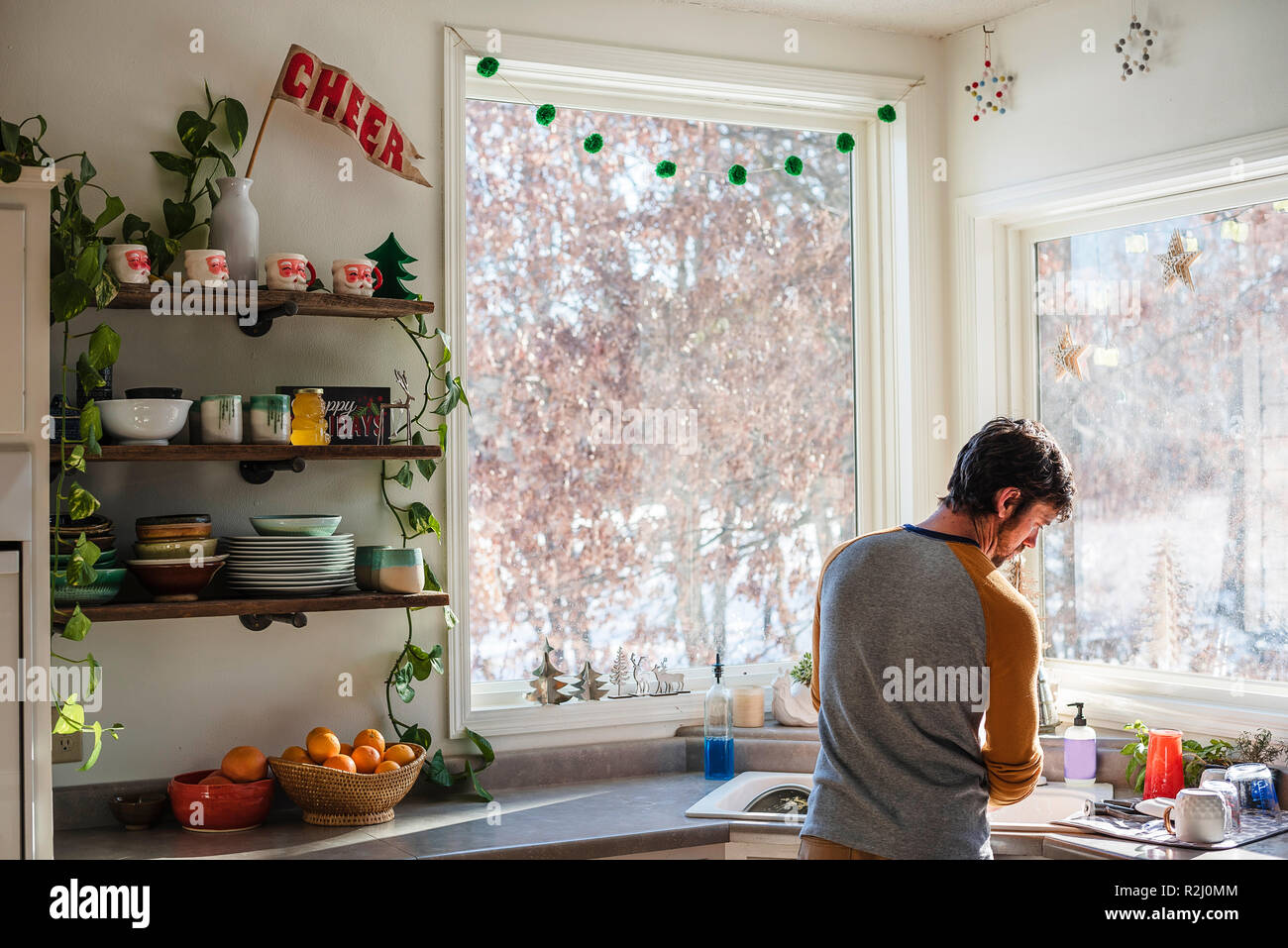 Man standing in the kitchen doing the dishes Stock Photo - Alamy