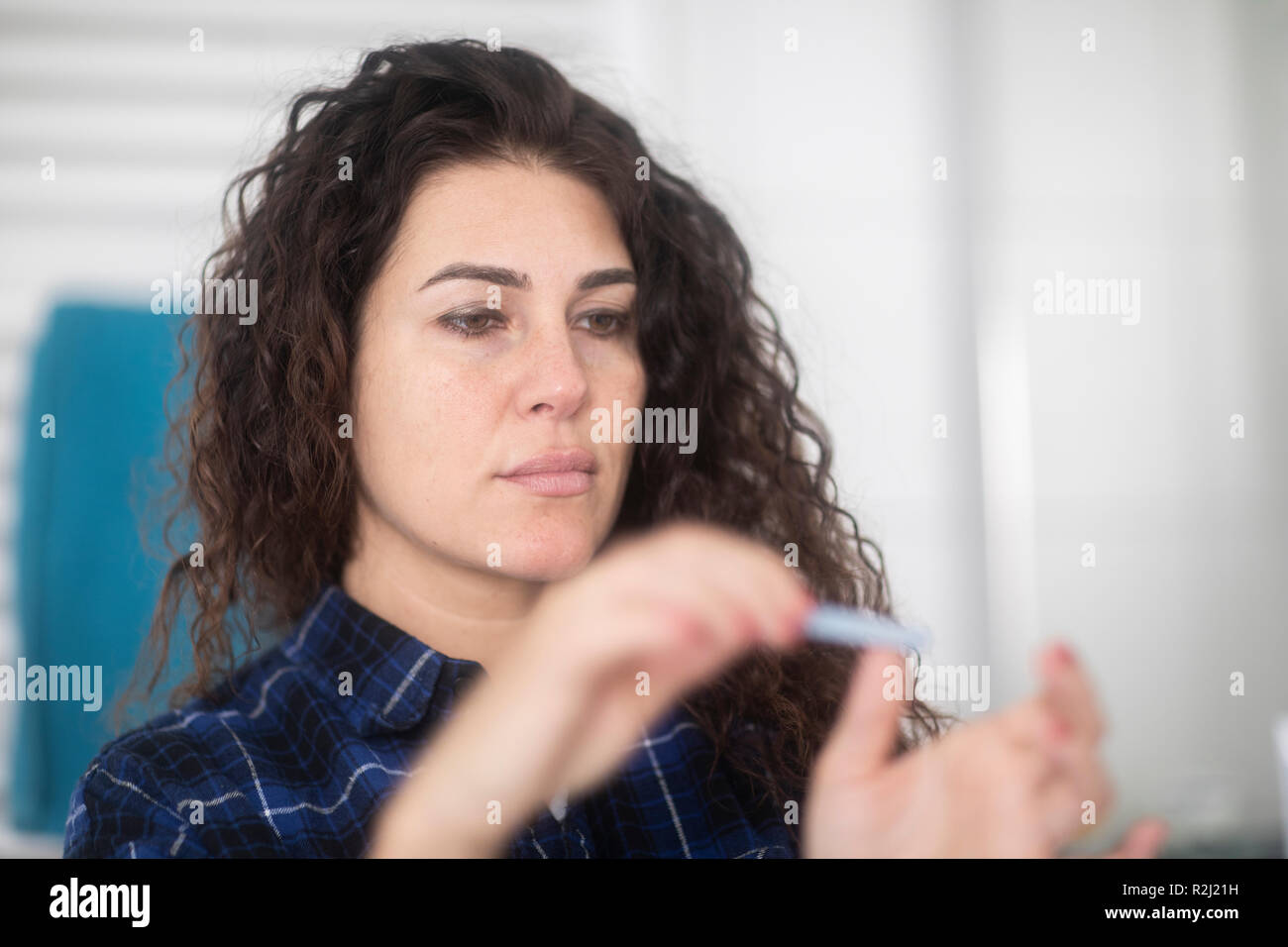Woman standing in the bathroom filing her nails Stock Photo - Alamy