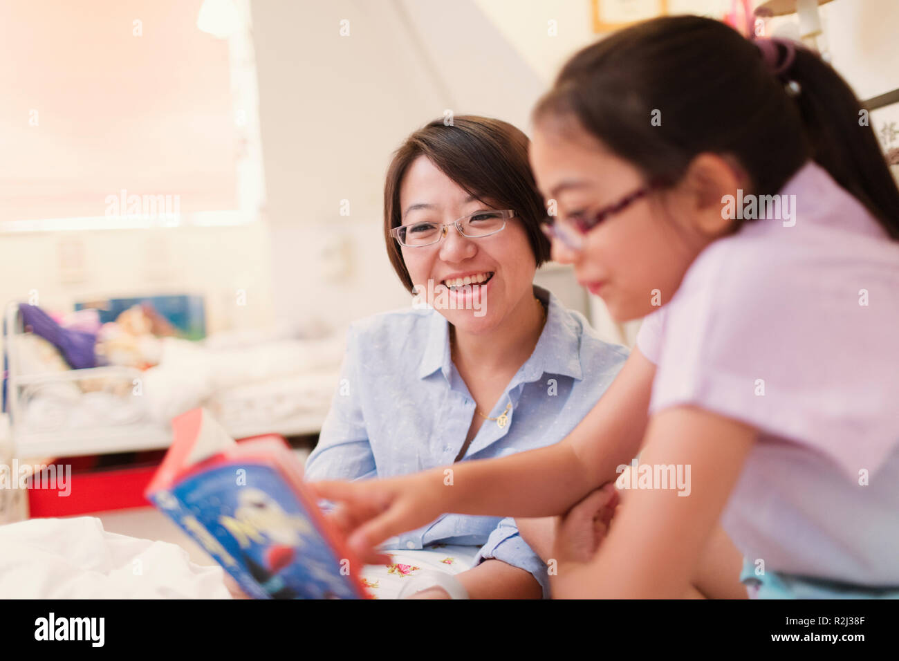 Mother reading to daughter in bed hi-res stock photography and images ...