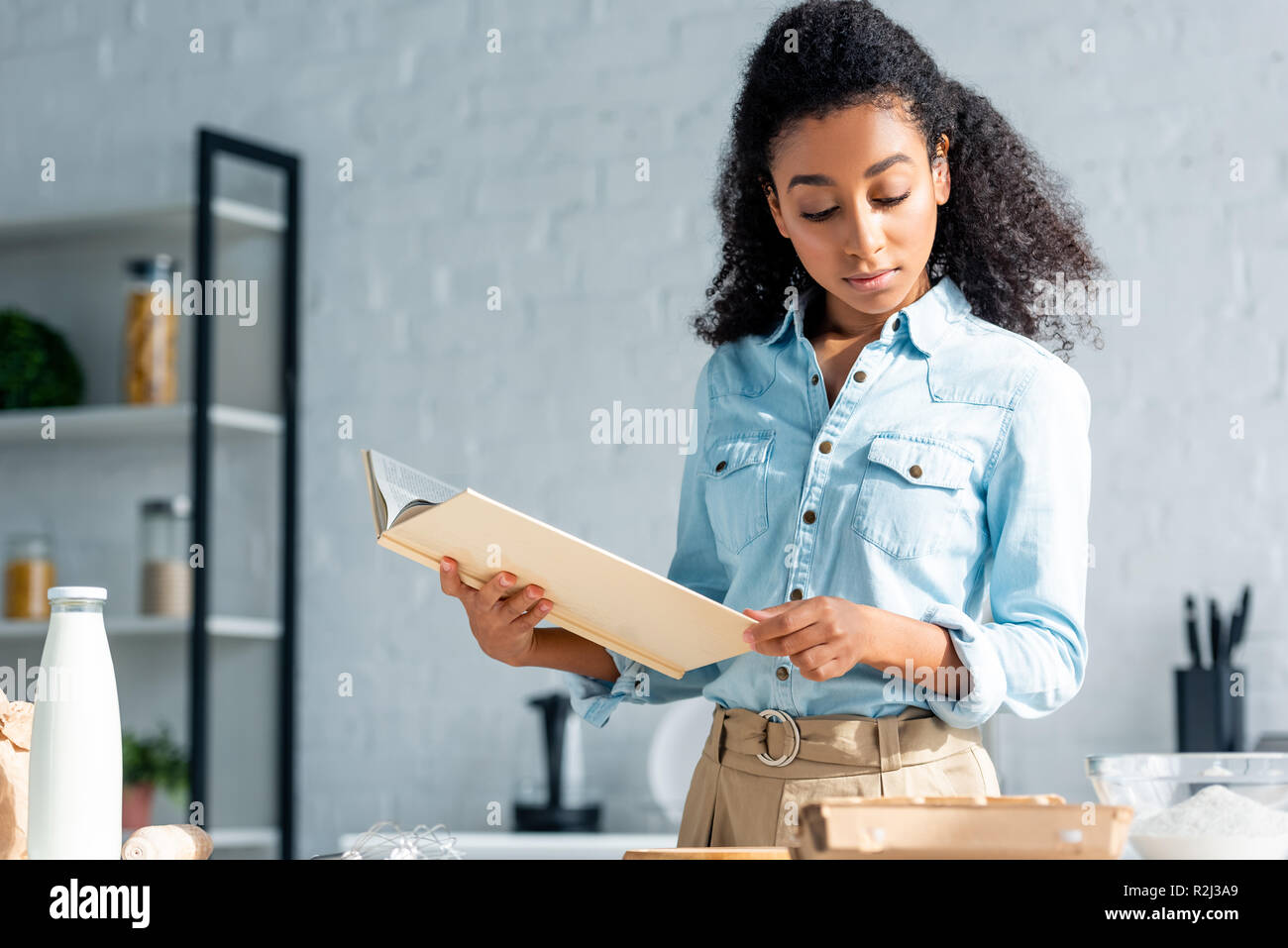 attractive african american girl holding cookbook in kitchen Stock ...