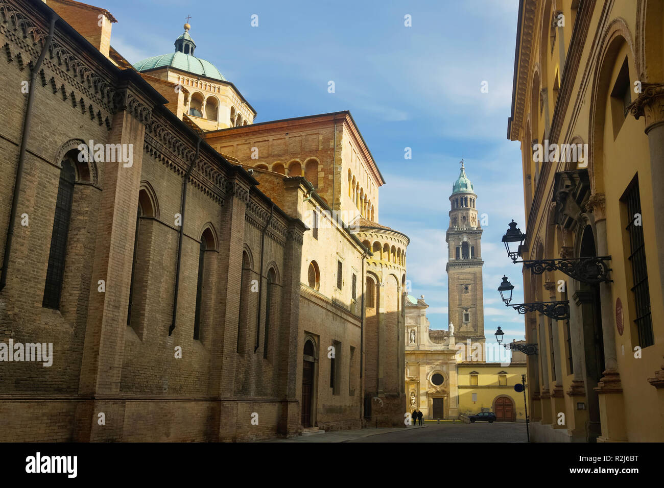View of narrow street of Italian city of Parma with belfry of San ...